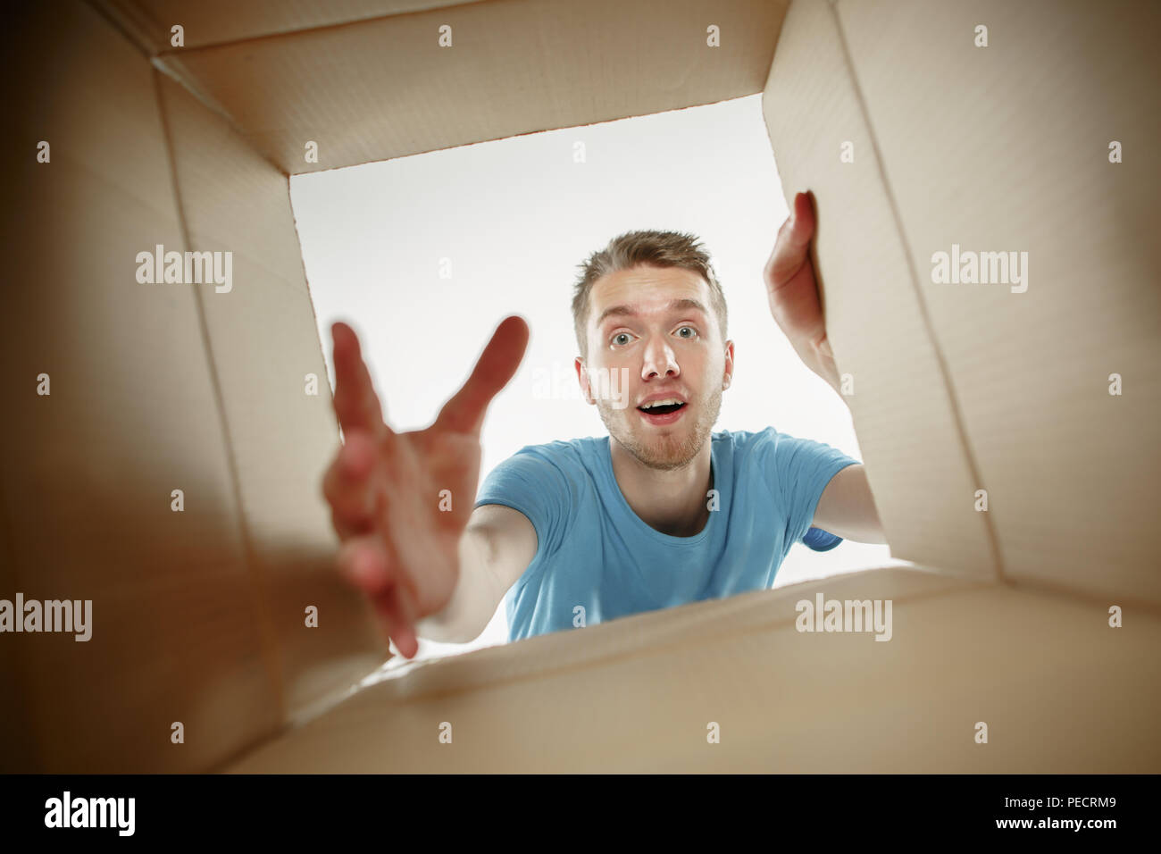 Man smiling, opening box and looking inside. The package, delivery ...