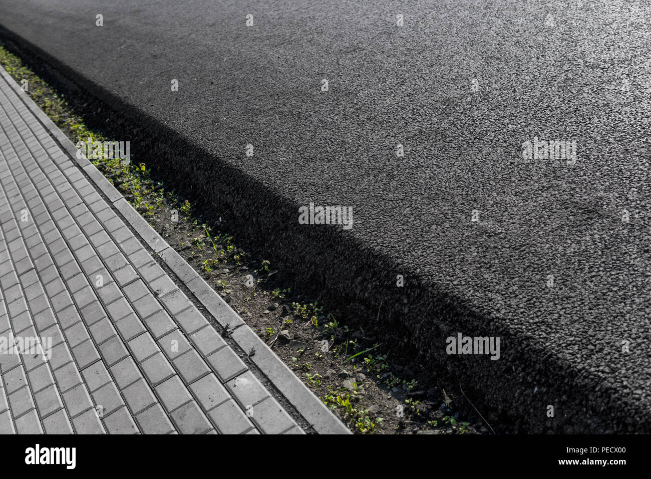 Close-up on a layer of new asphalt at the road under construction with ...