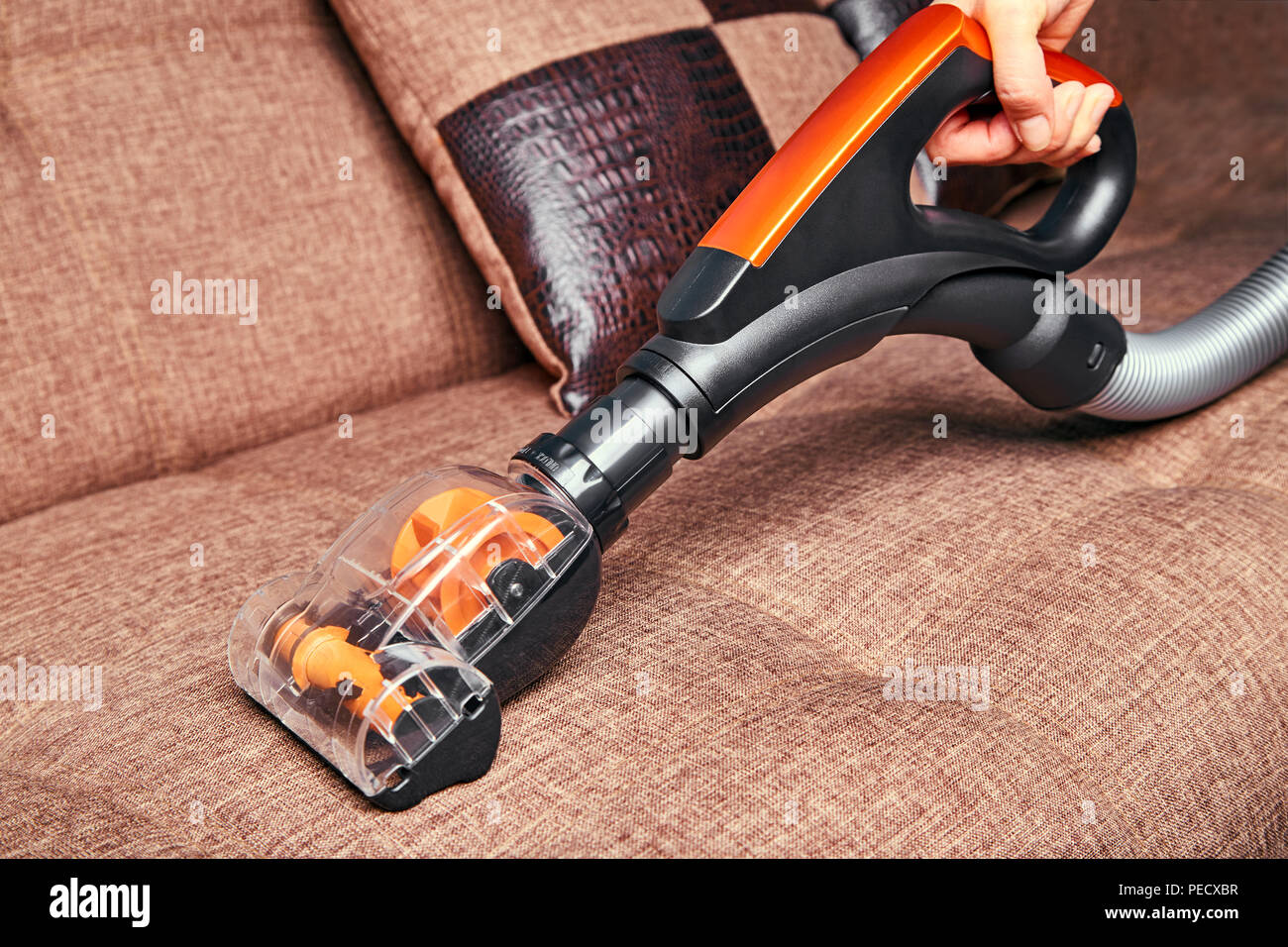 Crop person using handheld vacuum cleaner at home and washing sofa ...