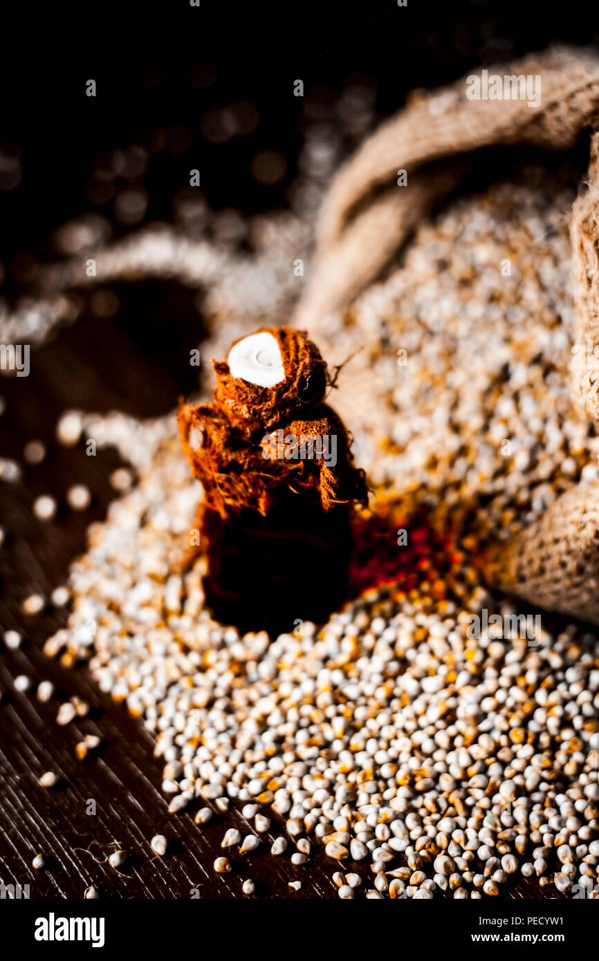 Close up of pearl millet oil with raw pearl millet on a wooden surface ...