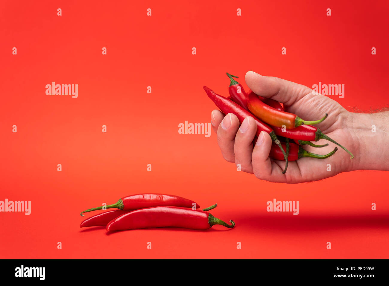 Image of red narrow long spicy chili peppers and men's hand holding ...