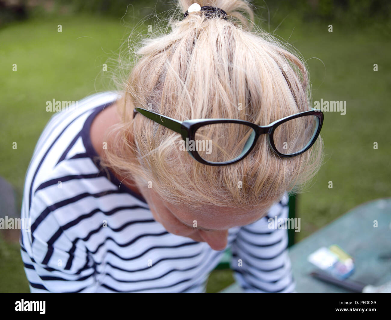 Closeup of a woman looking down with glasses on a top of her head Stock ...