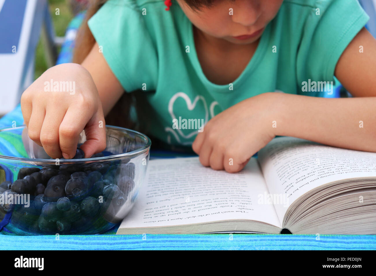 Little girl eating blueberries Stock Photo - Alamy