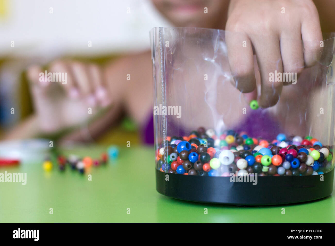 Child stringing beads hi-res stock photography and images - Alamy