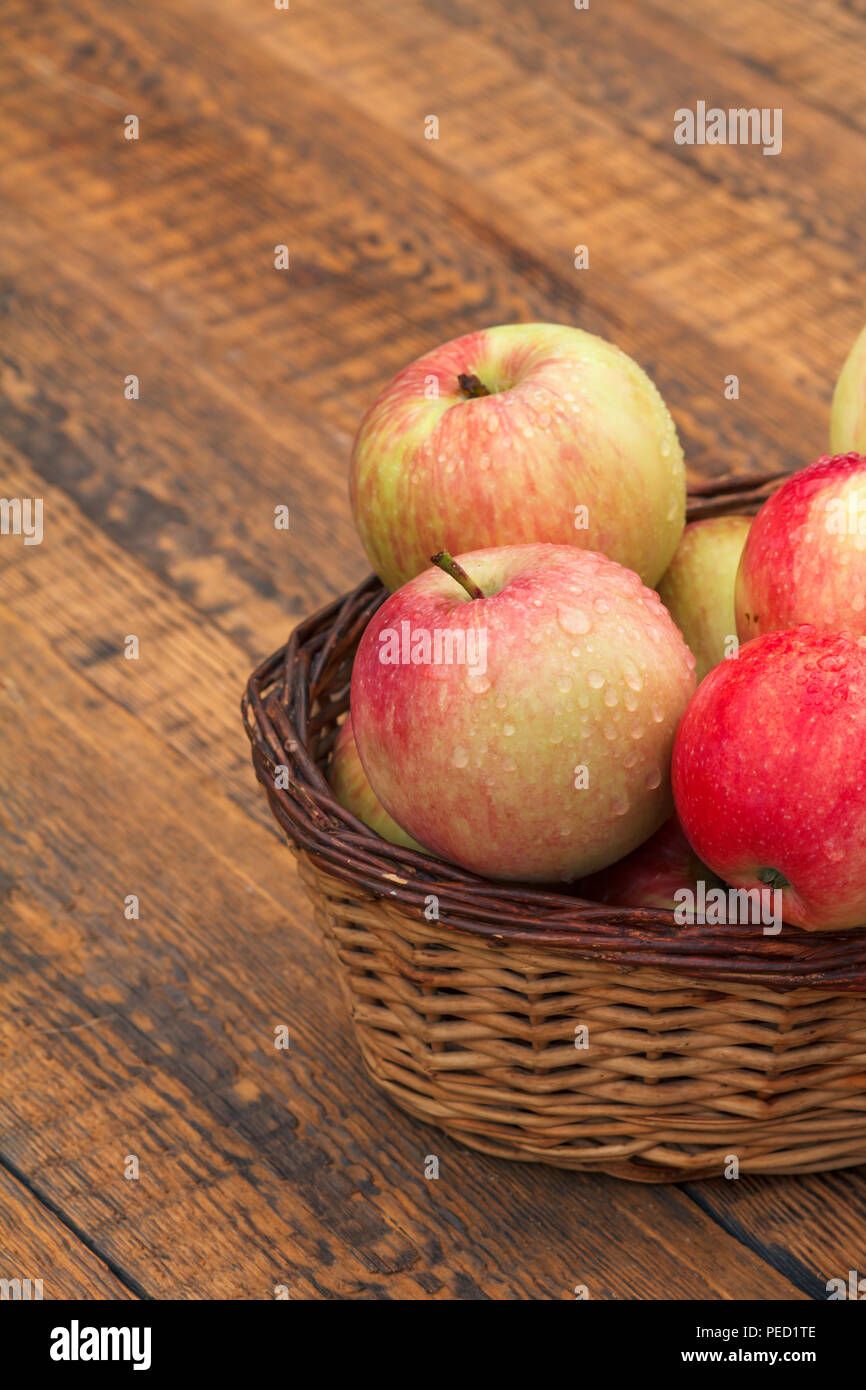 Red apples in wicker basket on old wooden boards. Top view Stock Photo ...