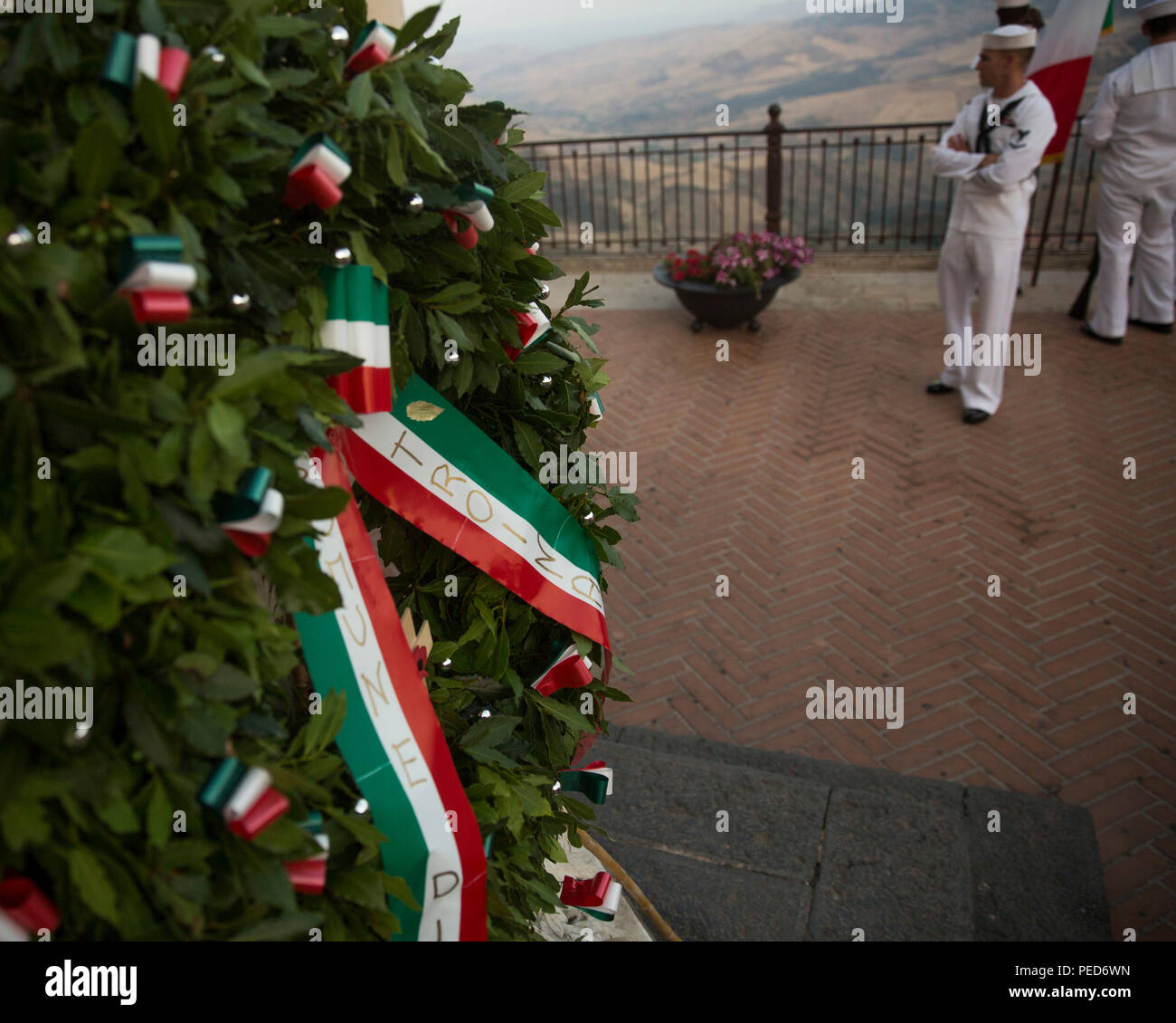A wreath is laid at the foot of a statue in the center of the town of ...