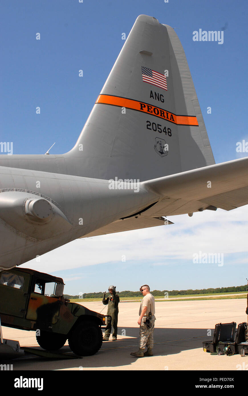 A loadmaster with the 169th Airlift Squadron, marshals a Humvee down a ...