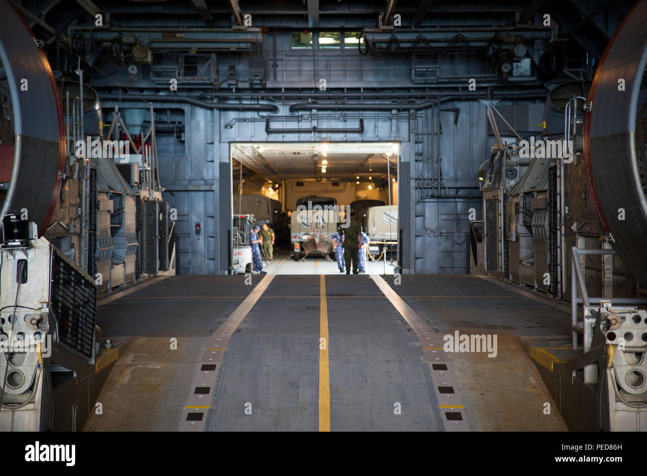 Japanese sailors aboard the JS Kunisaki (LST-4003) organize their gear ...