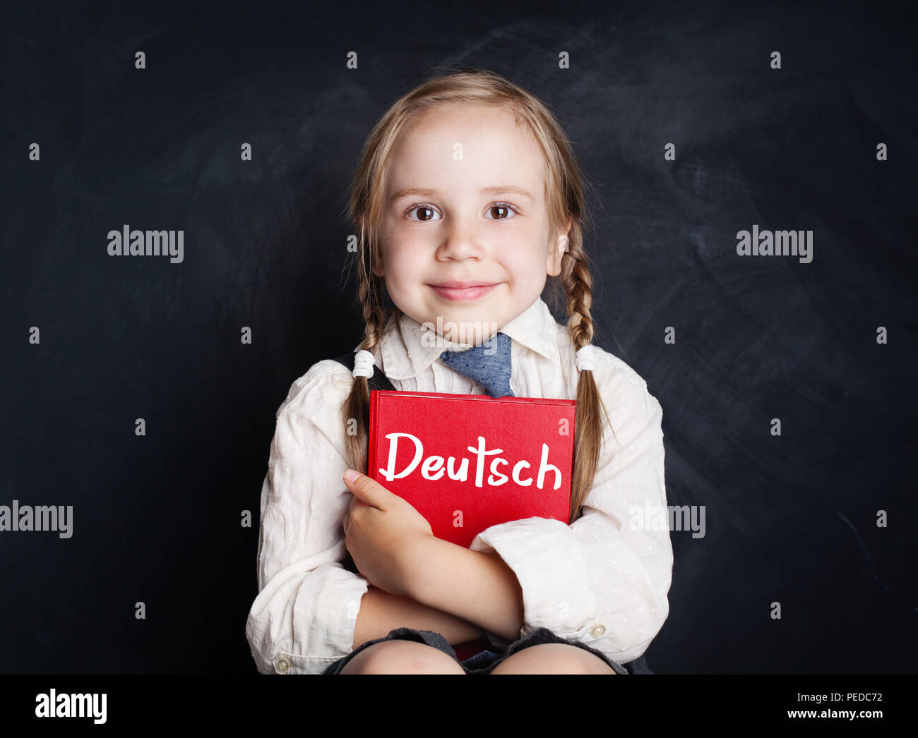 Speak german and learn language concept. Child schoolgirl holding red ...