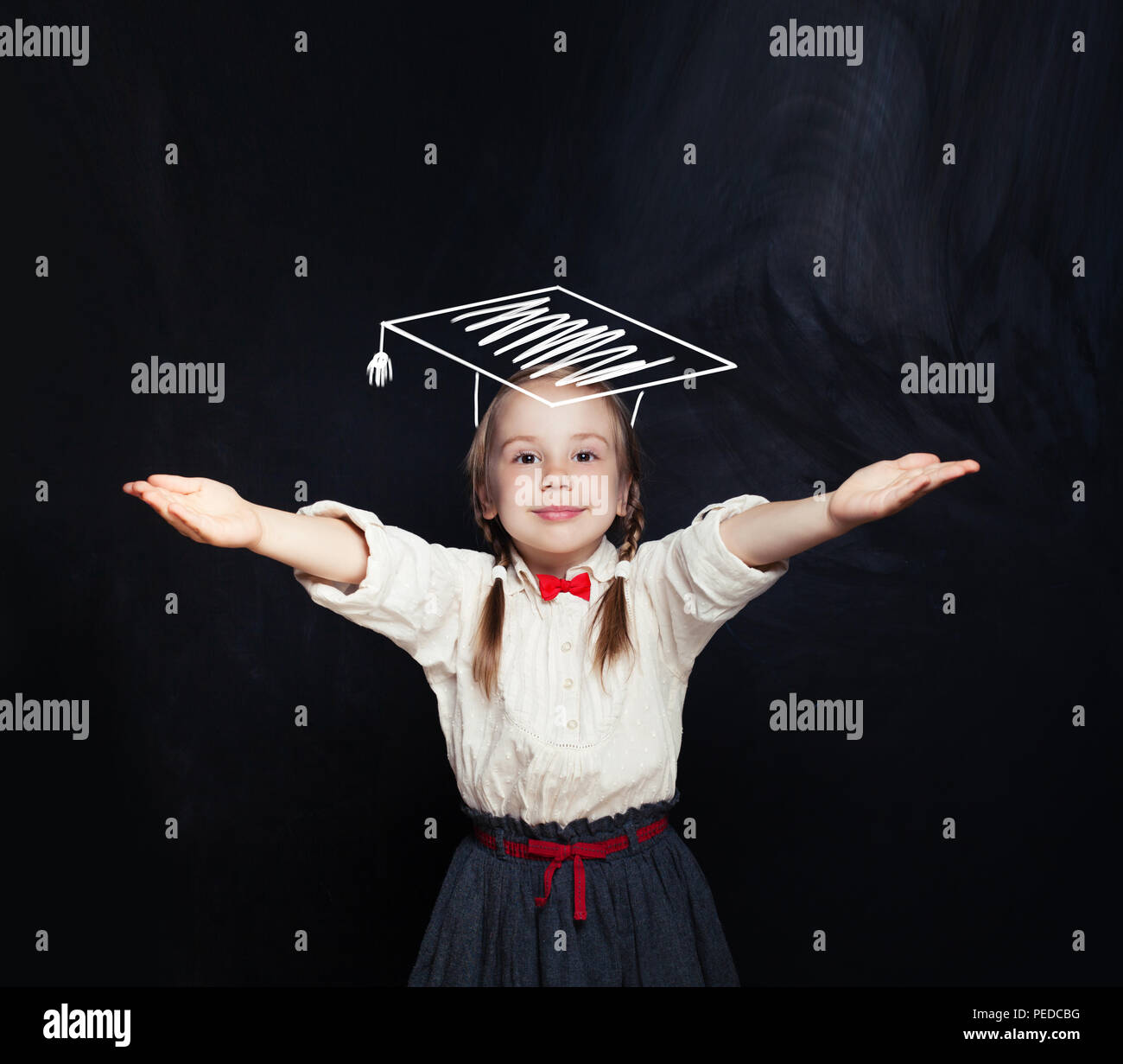 Child in graduation hat in classroom against chalkboard. School concept ...