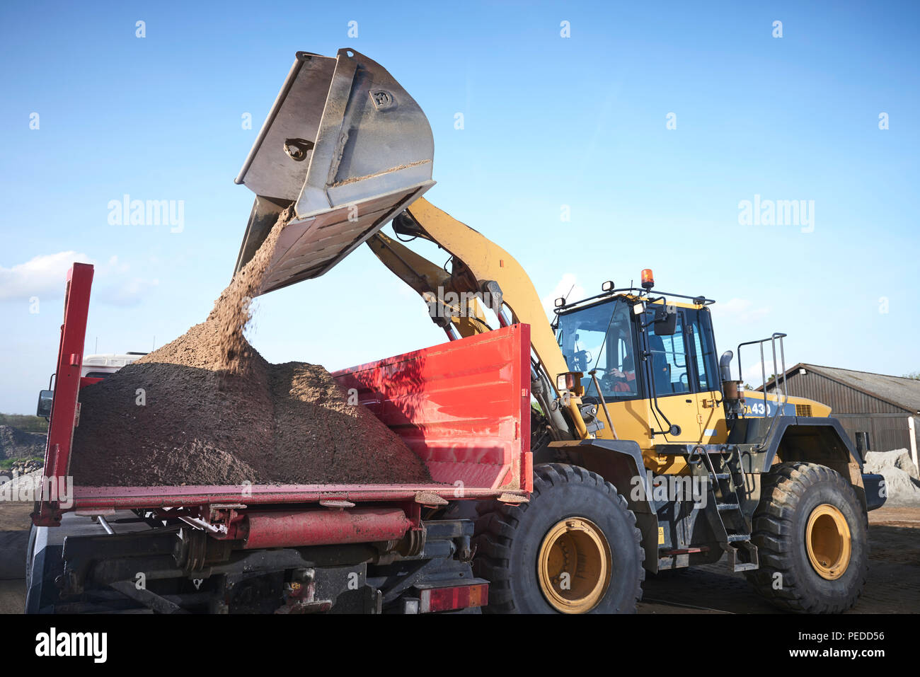 Excavator moving sand Stock Photo - Alamy