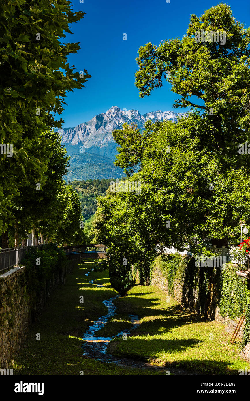 Summer river channel and mountains at Levico Terme, Trentino, Italy ...