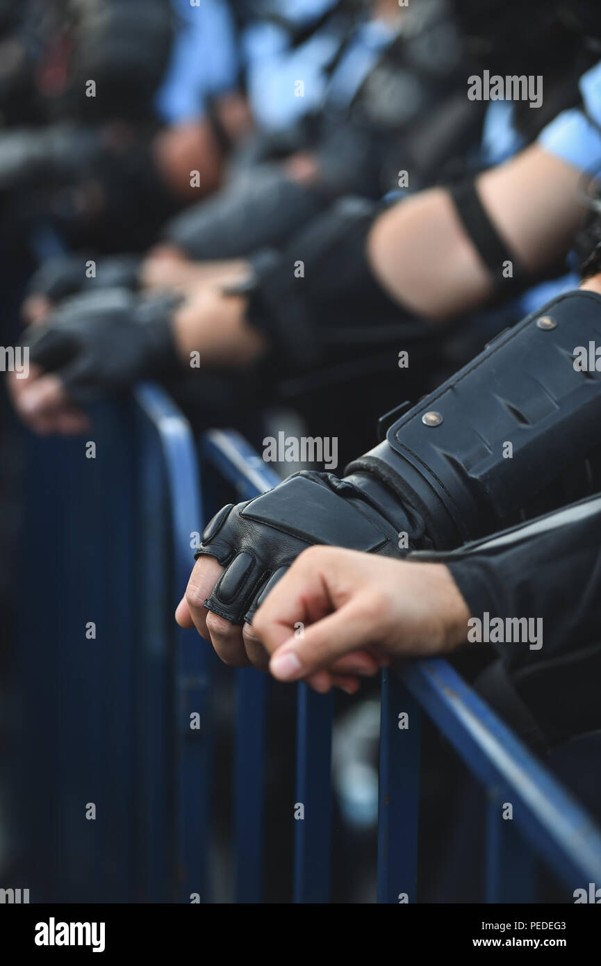 Police officer hands on a security fence during a riot Stock Photo - Alamy
