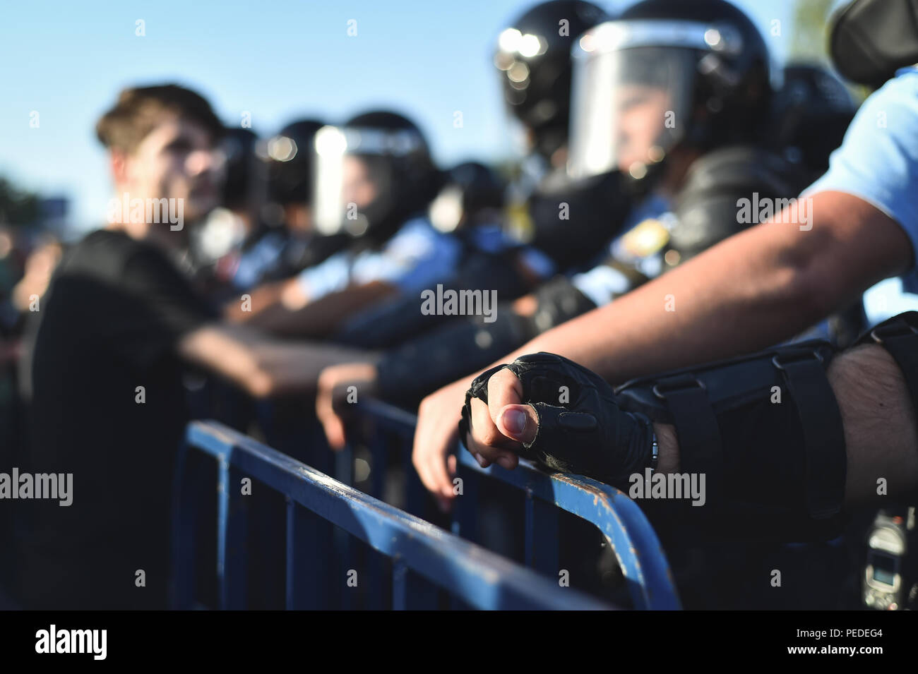Police officer hands on a security fence during a riot Stock Photo - Alamy