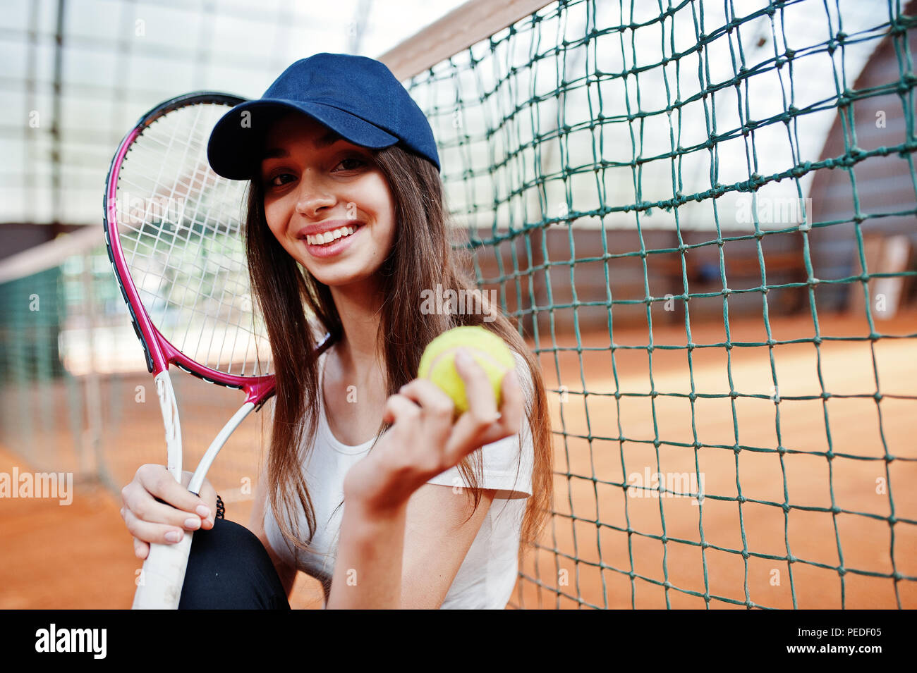 Young sporty girl player with tennis racket on tennis court Stock Photo ...