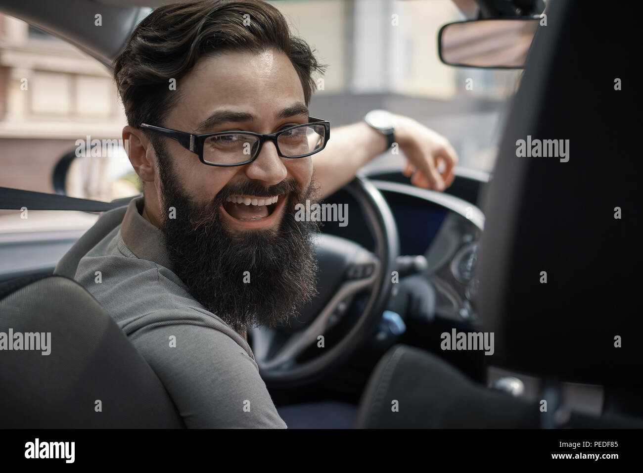 Happy charismatic man driving a car Stock Photo - Alamy