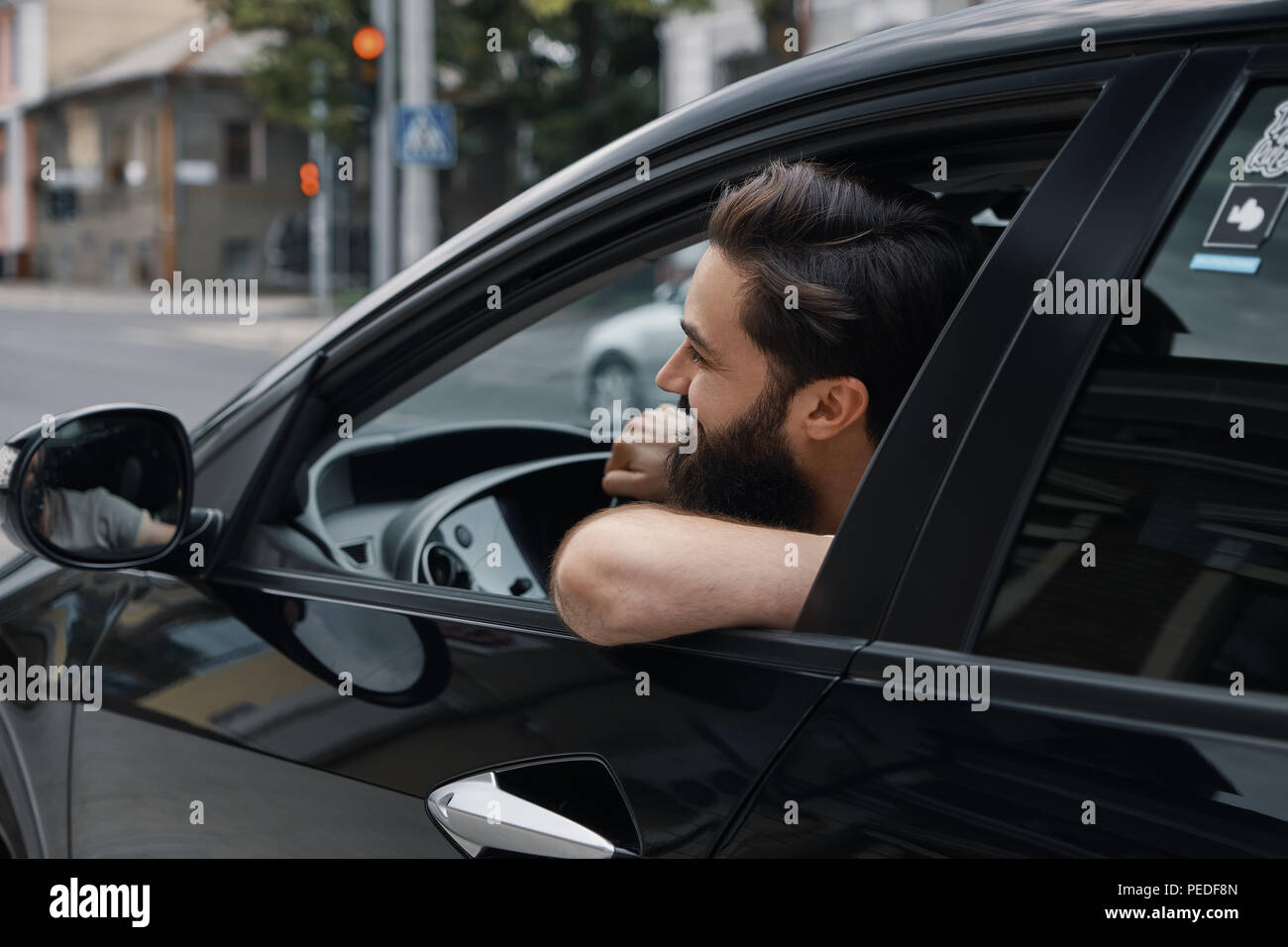 Young man smiling while driving a car Stock Photo - Alamy