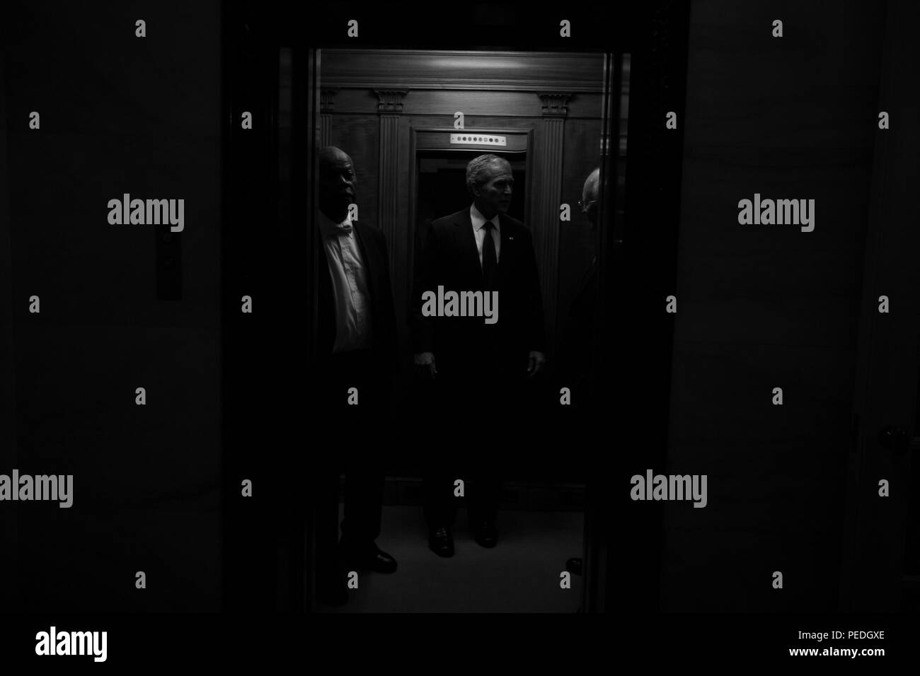 President George W Bush standing in dark room with advisors, Washington ...