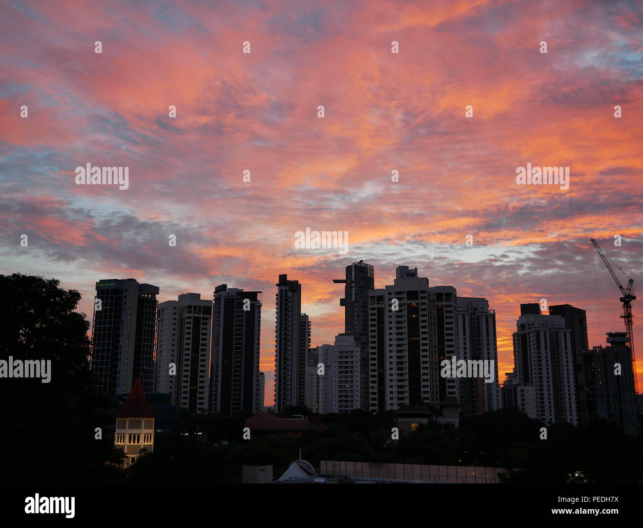 Sunset behind buildings with beautiful cloudy sky. Beautiful red ...