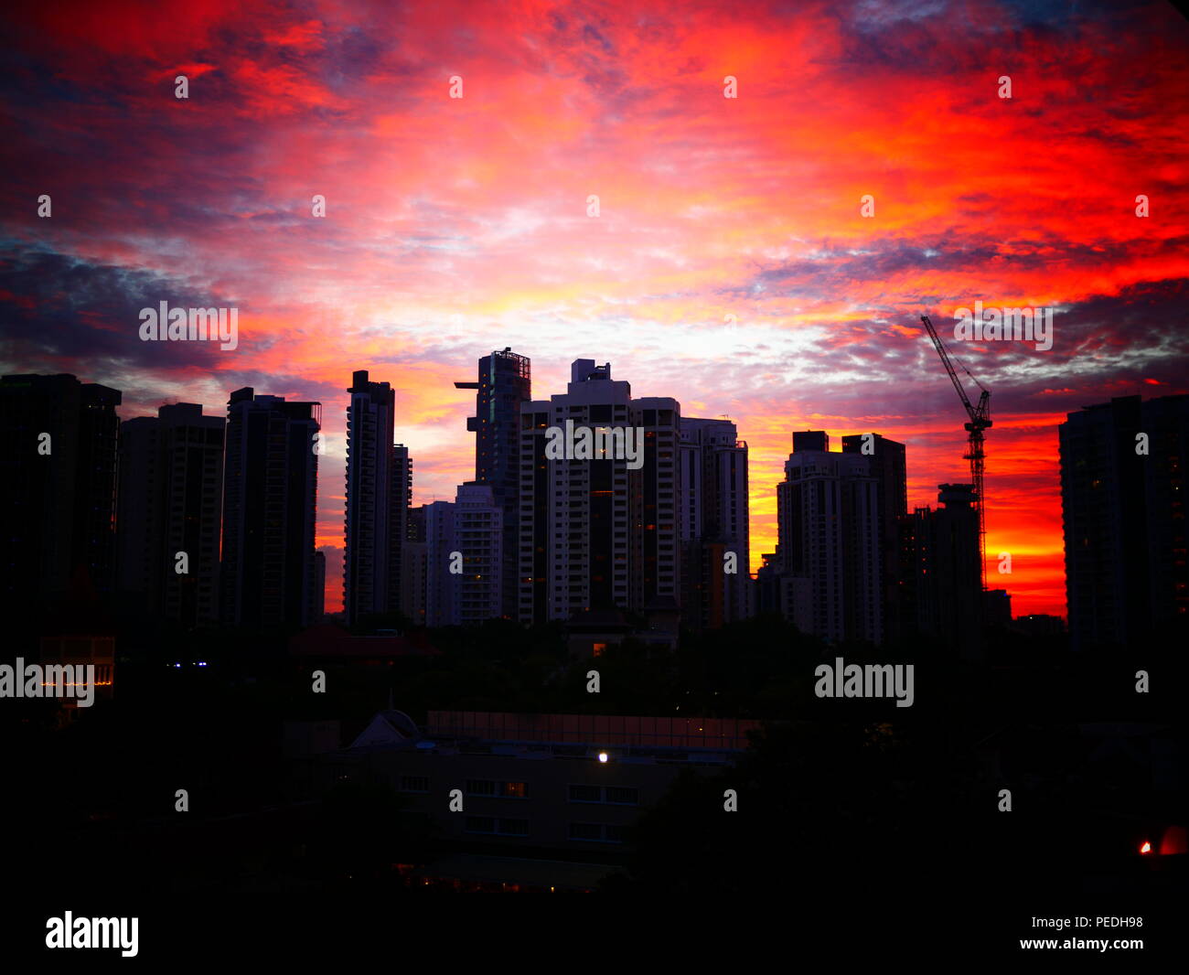 Sunset behind buildings with beautiful cloudy sky. Beautiful red ...