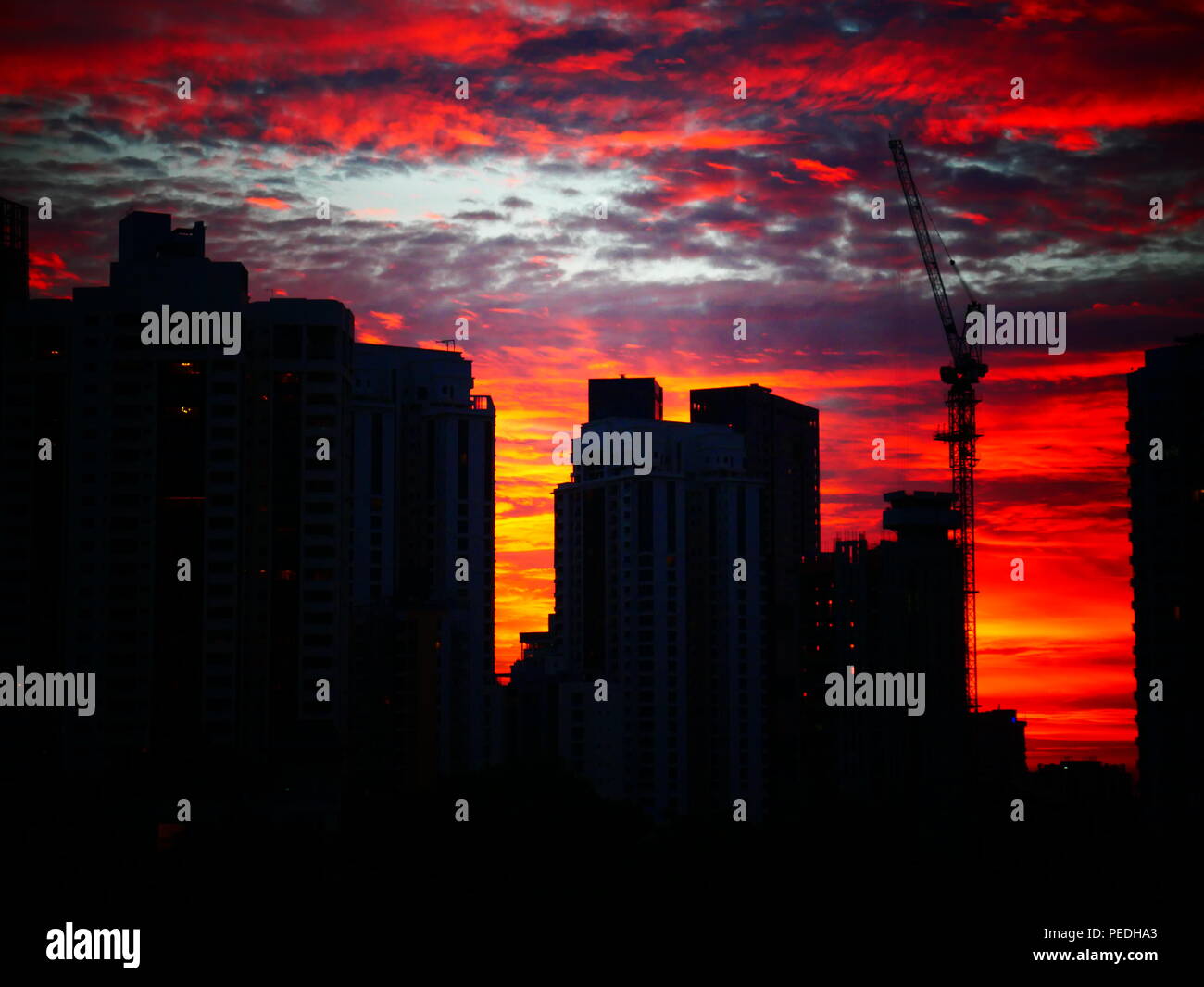 Sunset behind buildings with beautiful cloudy sky. Beautiful red ...