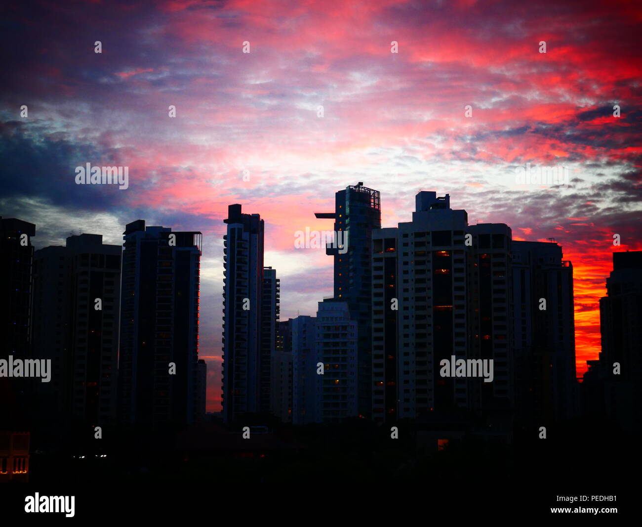 Sunset behind buildings with beautiful cloudy sky. Beautiful red ...