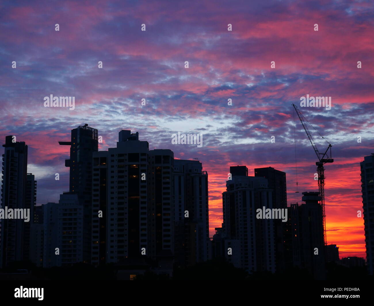 Sunset behind buildings with beautiful cloudy sky. Beautiful red ...