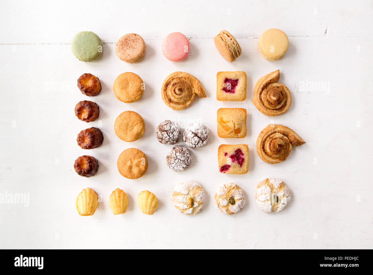 A playful selection of cakes and pastries laid out in patterns and ...