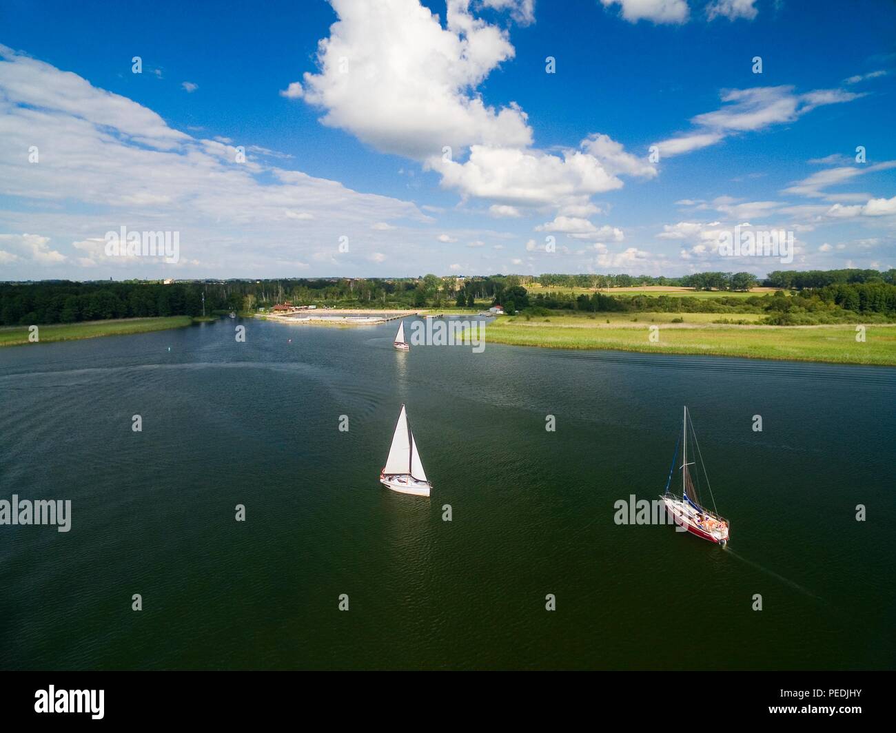 Aerial view of yachts sailing on Mamry Lake, concrete quay and town ...