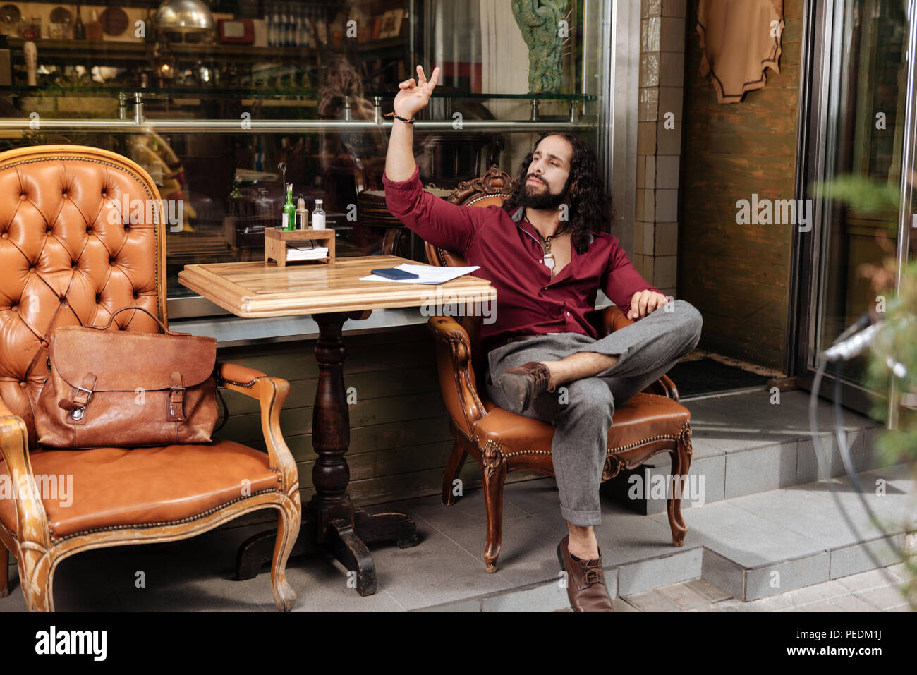 Nice brunette man calling the waiter Stock Photo - Alamy