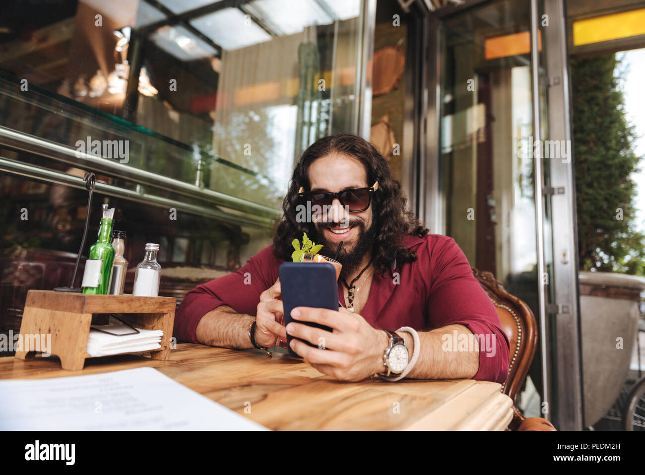 Cheerful positive man using his gadget Stock Photo - Alamy