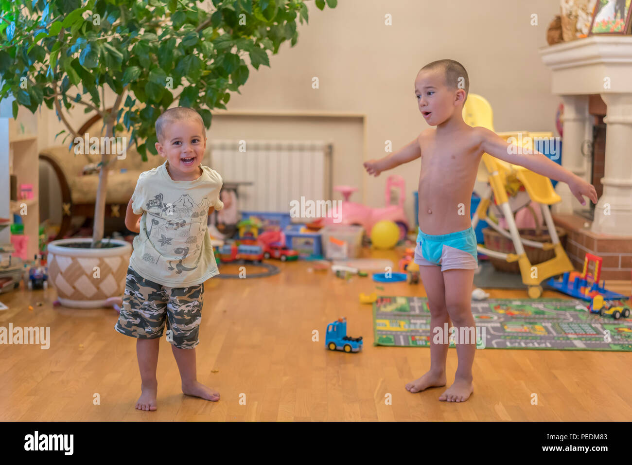 Two small boys at home doing sports. Children make exercises. Two ...