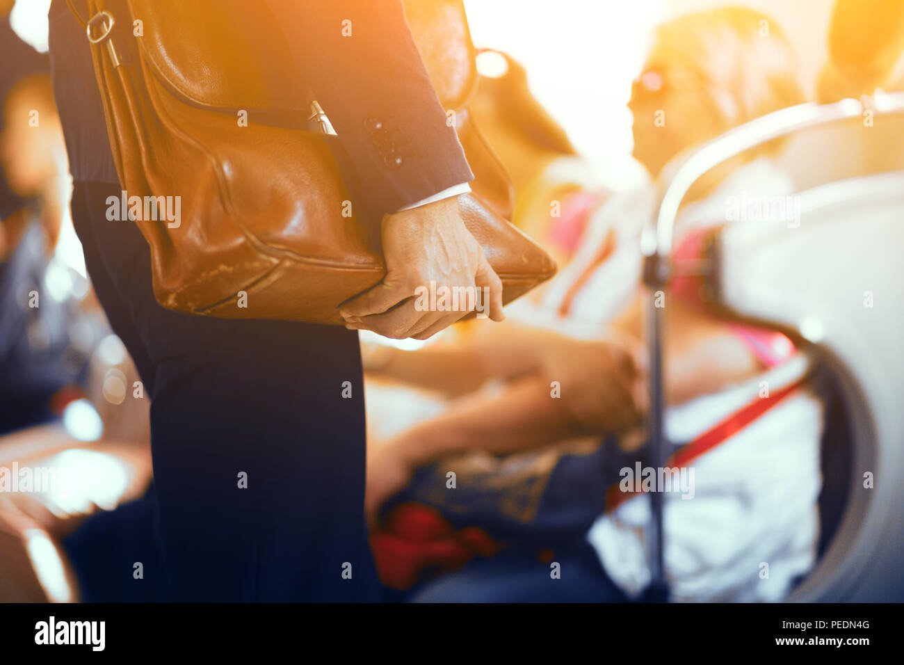 Man holding leather bag while on train Stock Photo - Alamy