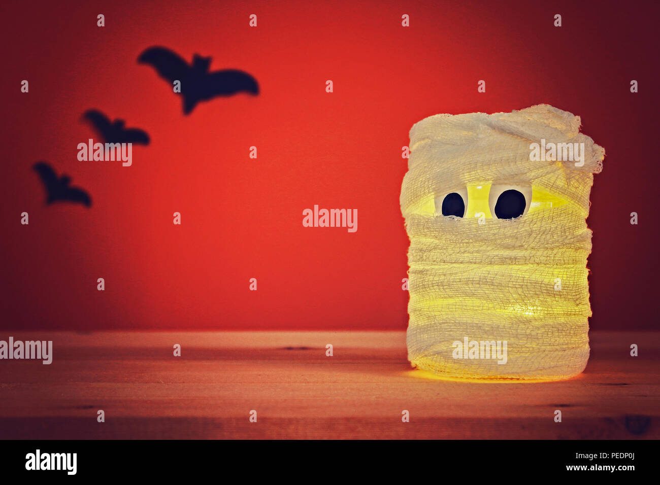 The concept for Halloween. Bats and mummy from a jar, bandages and ...