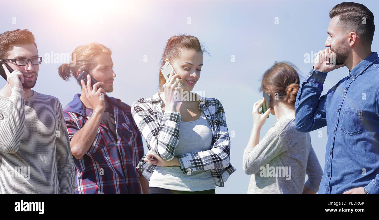 group of young people talking on their smartphones.photo with copy ...