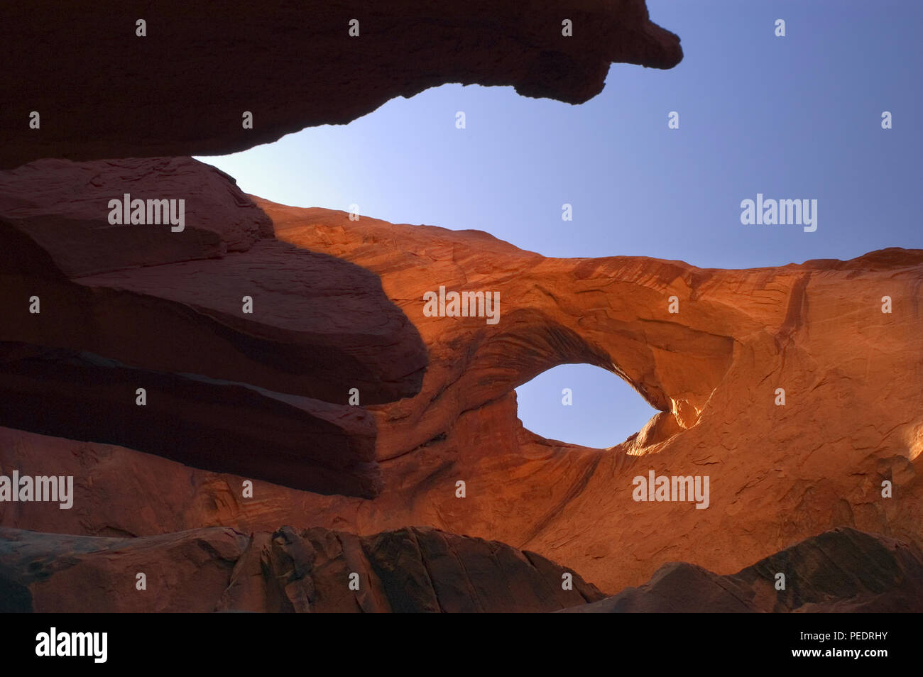 Red Rocks and blue sky with an eye like window in the rock at Monument ...