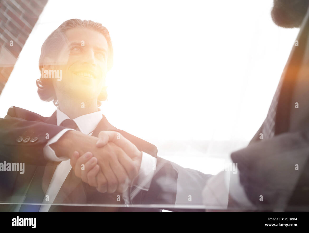 bottom view. confident handshake of business partners sitting at a Desk ...