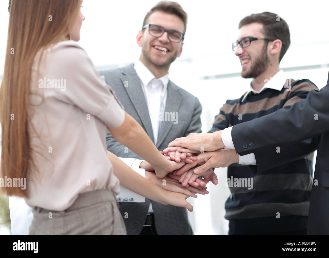 Business team standing joining hands together Stock Photo - Alamy
