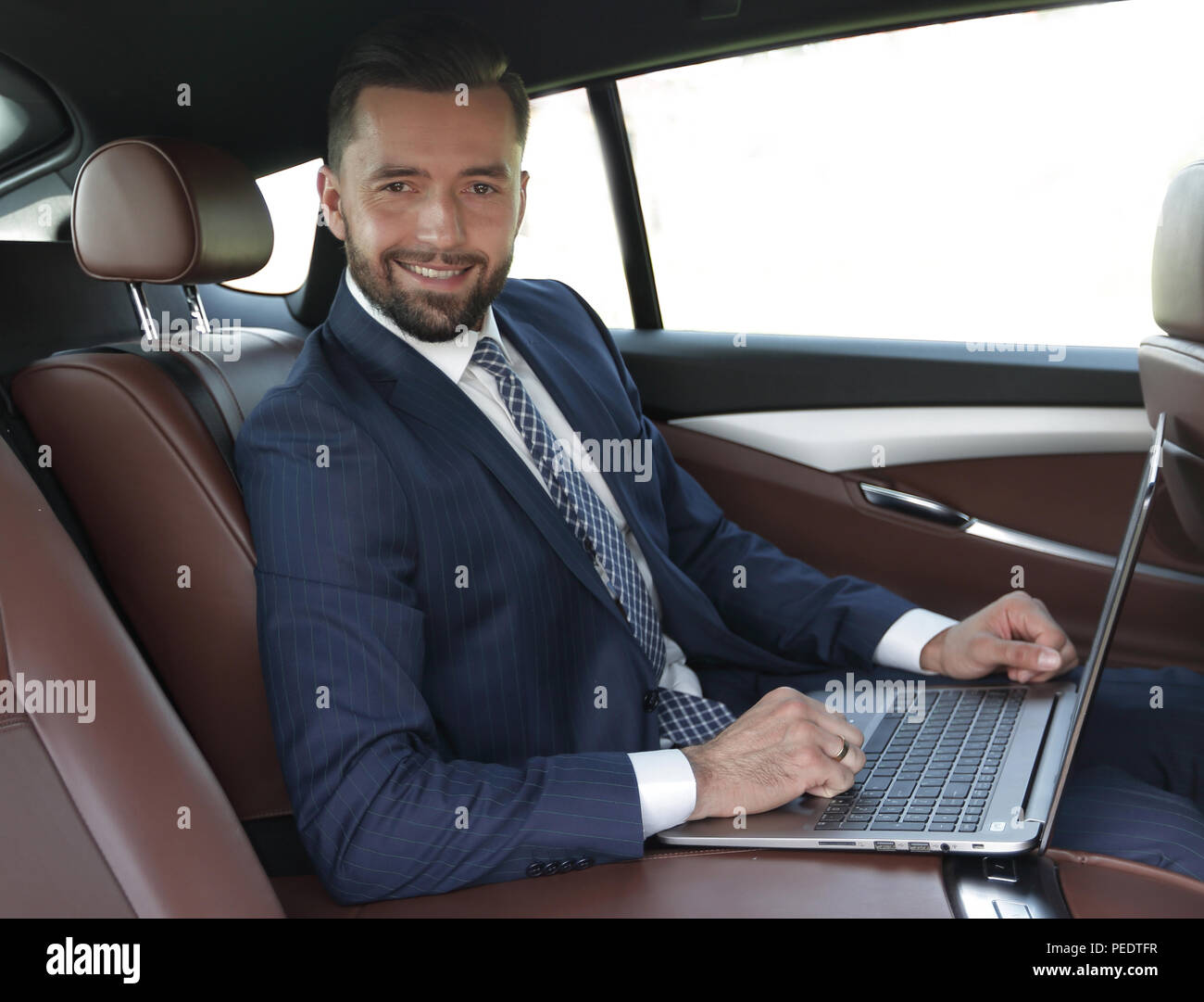 Businessman working on laptop keyboard sitting in car Stock Photo - Alamy