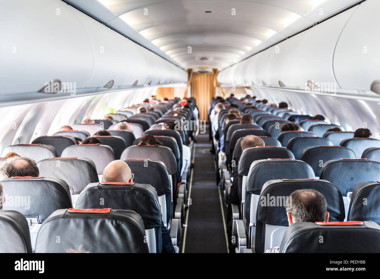 Interior of commercial airplane with passengers on their seats during ...