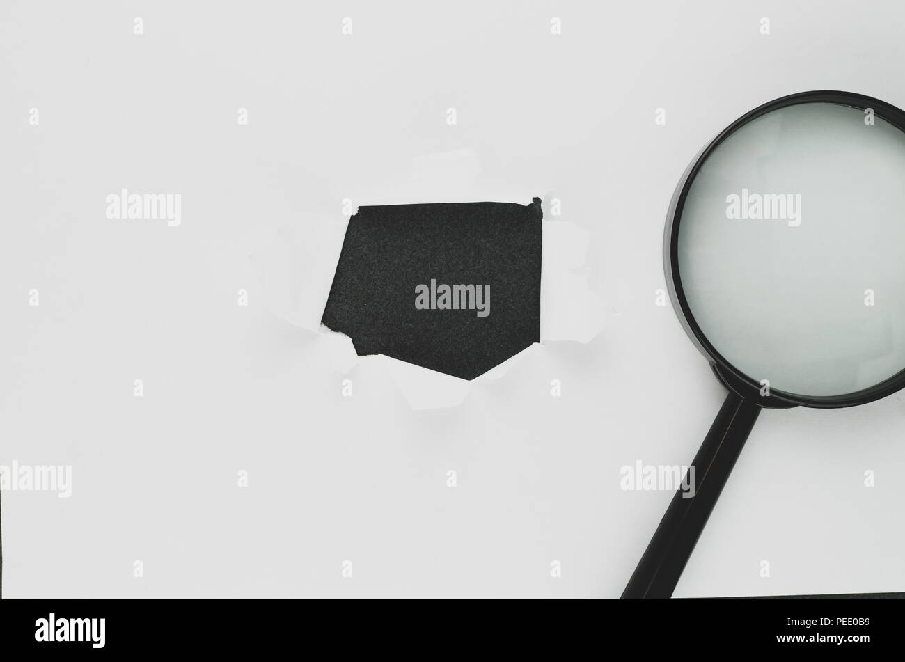 white ripped paper background and magniyfing glass Stock Photo - Alamy