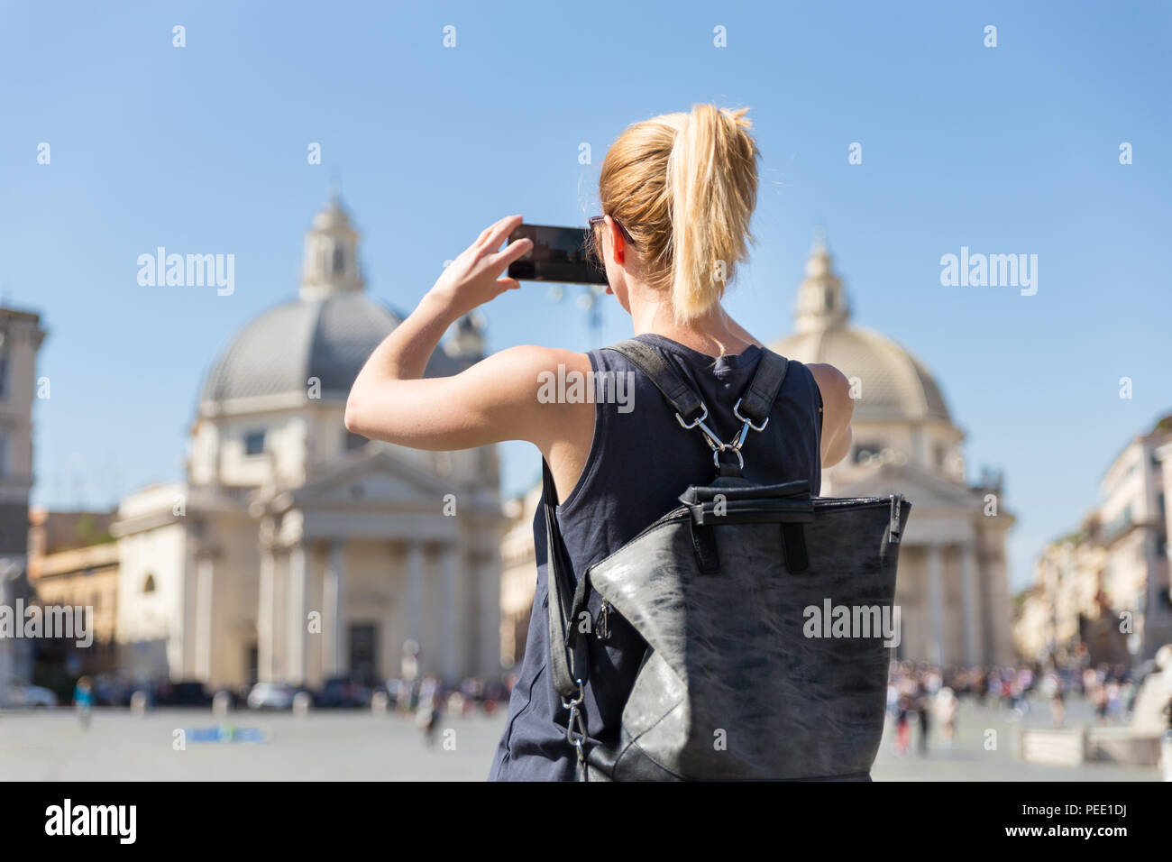 Female tourist with a fashinable vintage hipster backpack taking photo ...