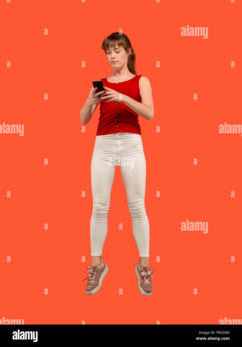 always on mobile. Full length of pretty young woman taking phone while ...