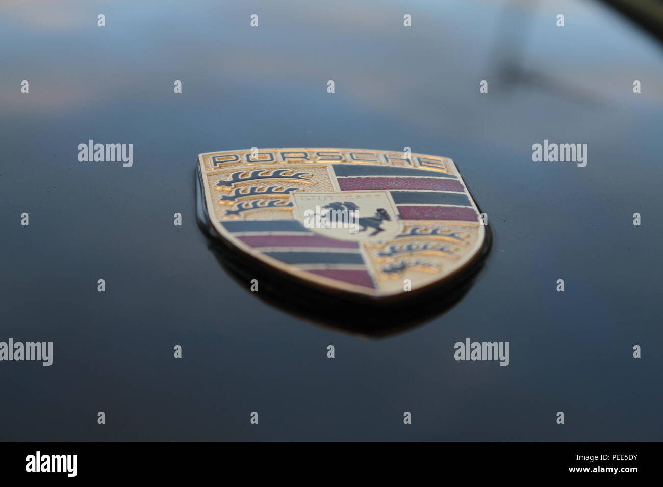 Porsche logo on a blue car Stock Photo - Alamy