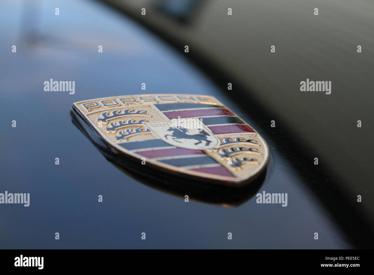 Porsche logo on a blue car Stock Photo - Alamy