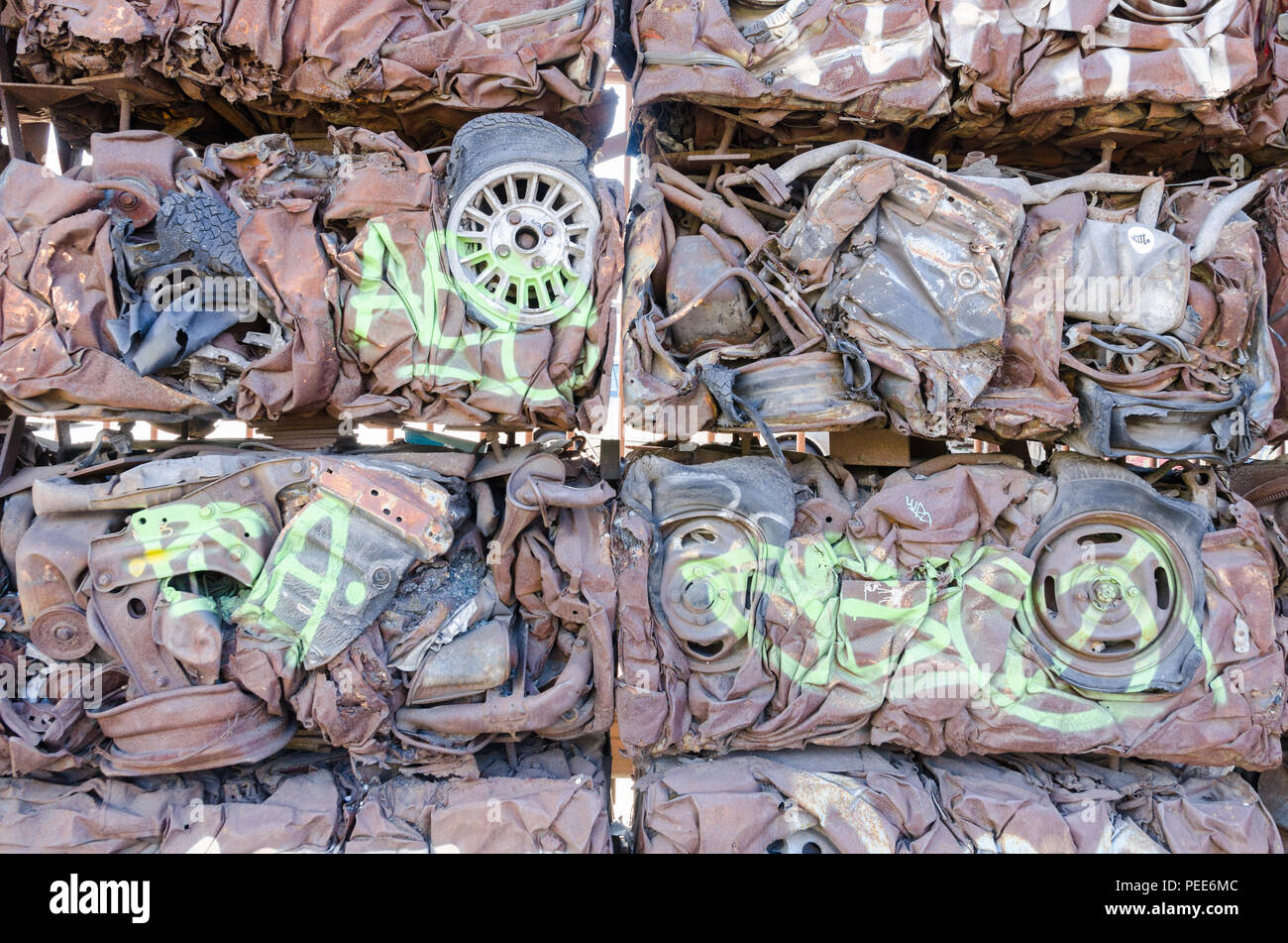 Crushed cars used as building blocks to build a wall at car park in ...