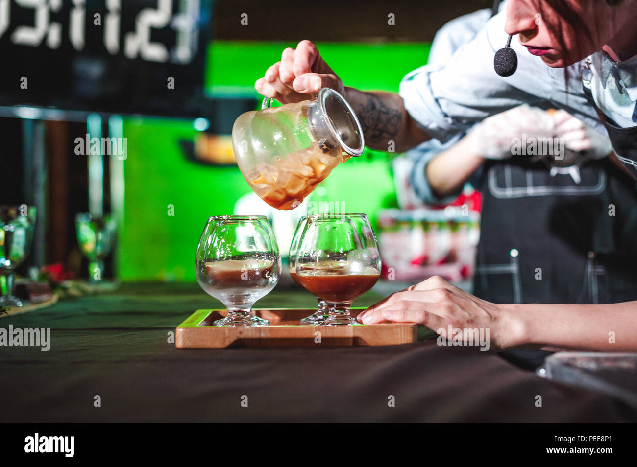 women's hands professionally barista pour the prepared drink into glass ...