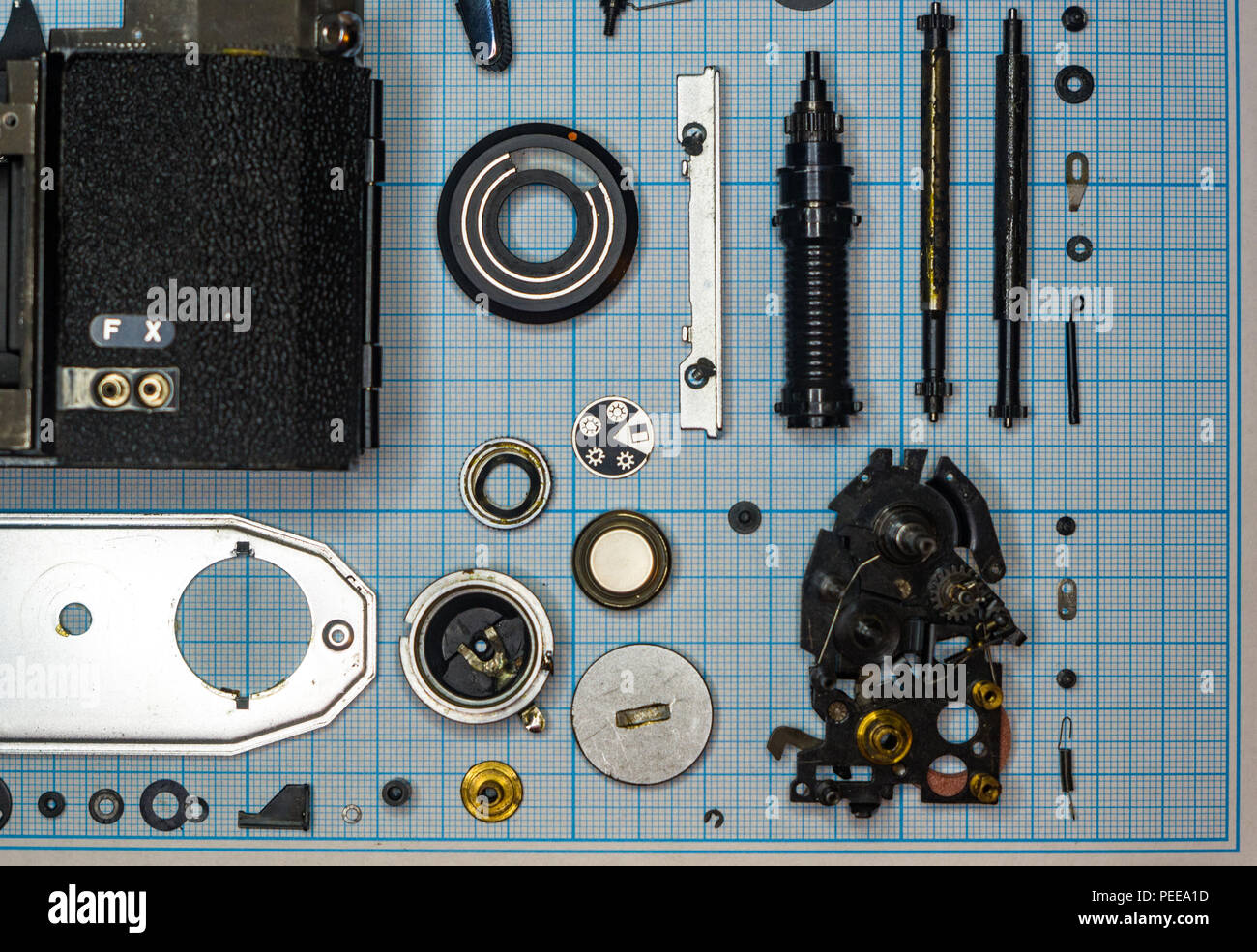 parts are completely disassembled old retro film SLR camera on graph ...