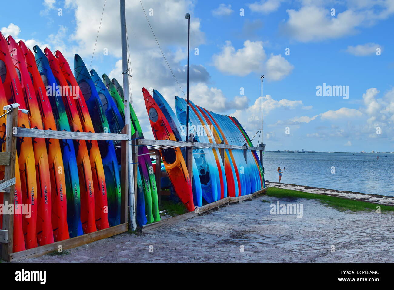 Kayak and boat rental beach side with Tiki bar and man in background ...