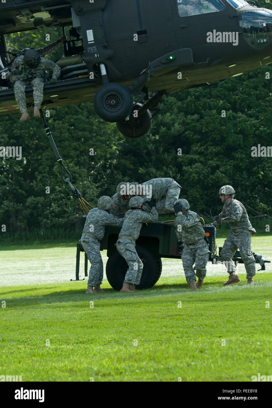 The 40th Army Band Soldiers hook a sling load to a Charlie Company, 3rd ...